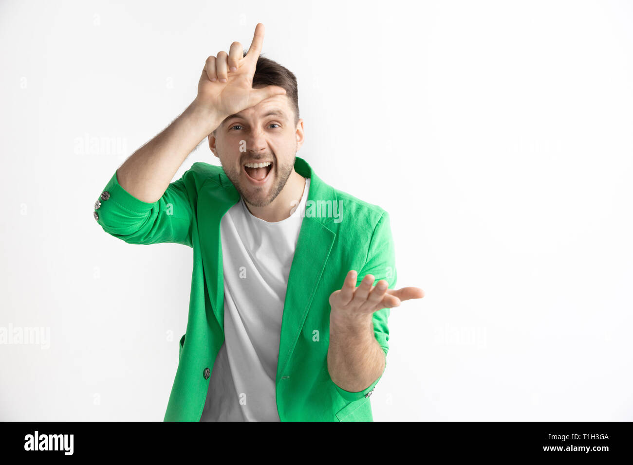 Losers go home. Portrait of happy guy showing loser sign over forehead ...