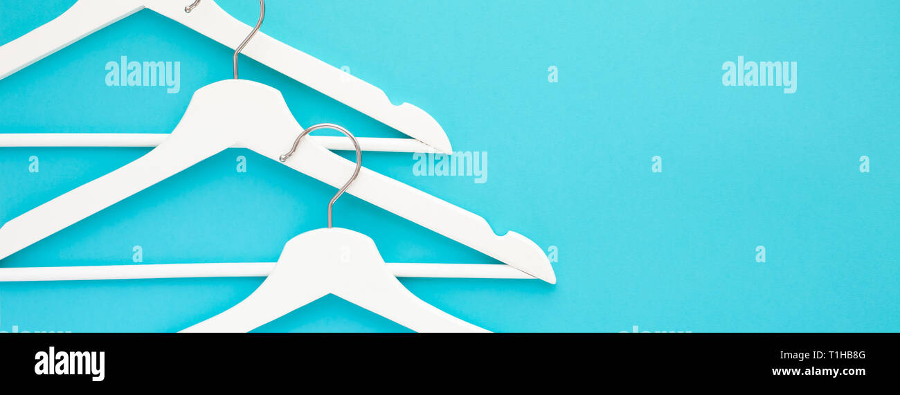 Creative top view flat lay white wooden hangers isolated bold blue ...