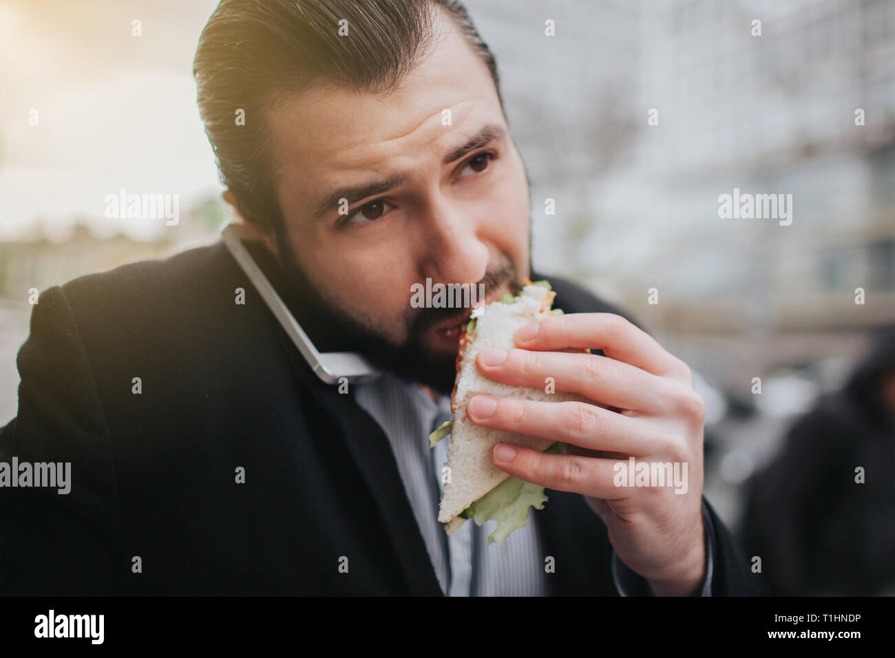 Business man eating snack walking hi-res stock photography and images ...