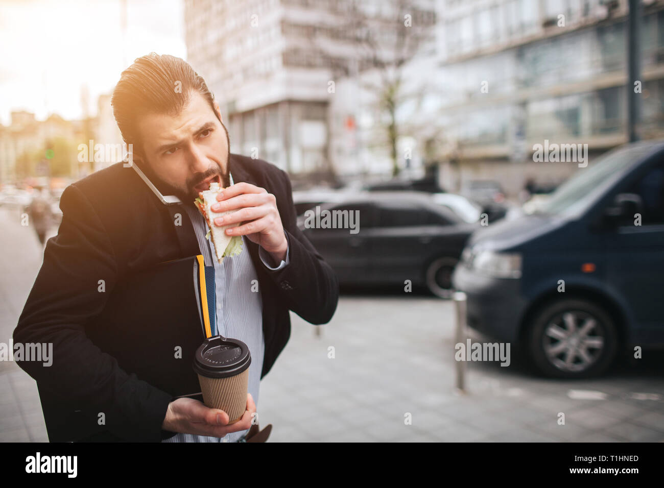 Business man eating snack walking hi-res stock photography and images ...