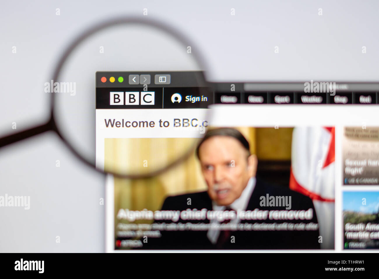 BBC News website homepage. BBC logo visible through a magnifying glass ...