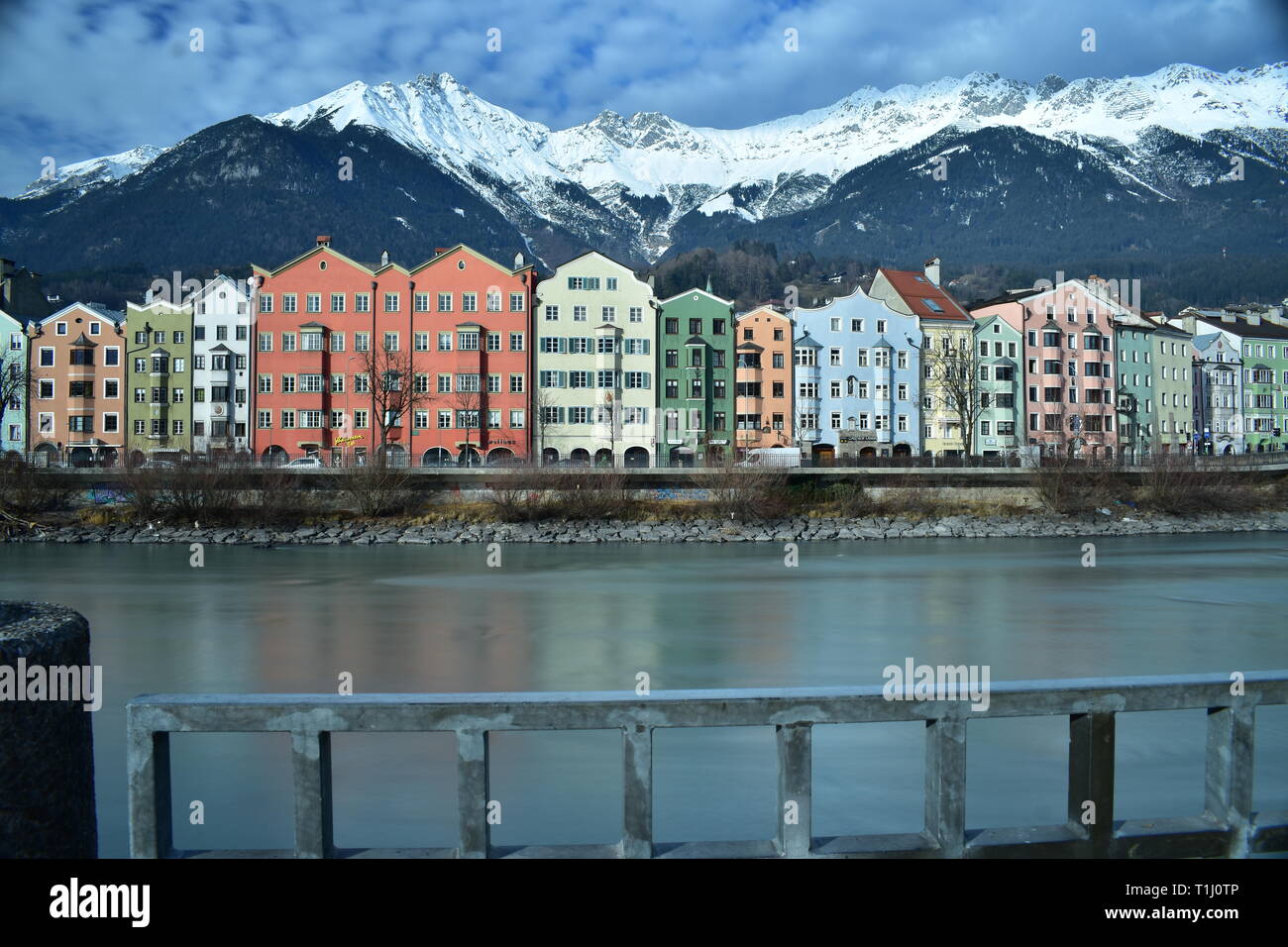 The Austrian alps behind the river "Inn" and Colorful houses. This ...