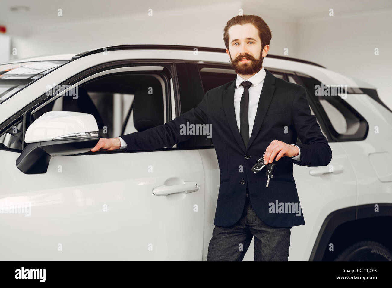 Handsome and elegant man in a car salon Stock Photo - Alamy