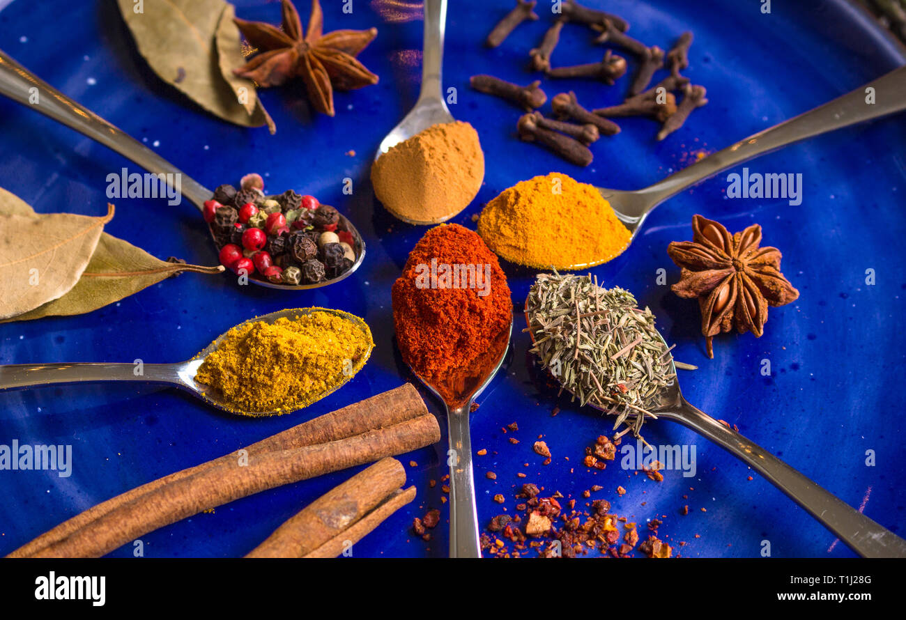 Different colorful spices on dark blue background Stock Photo - Alamy