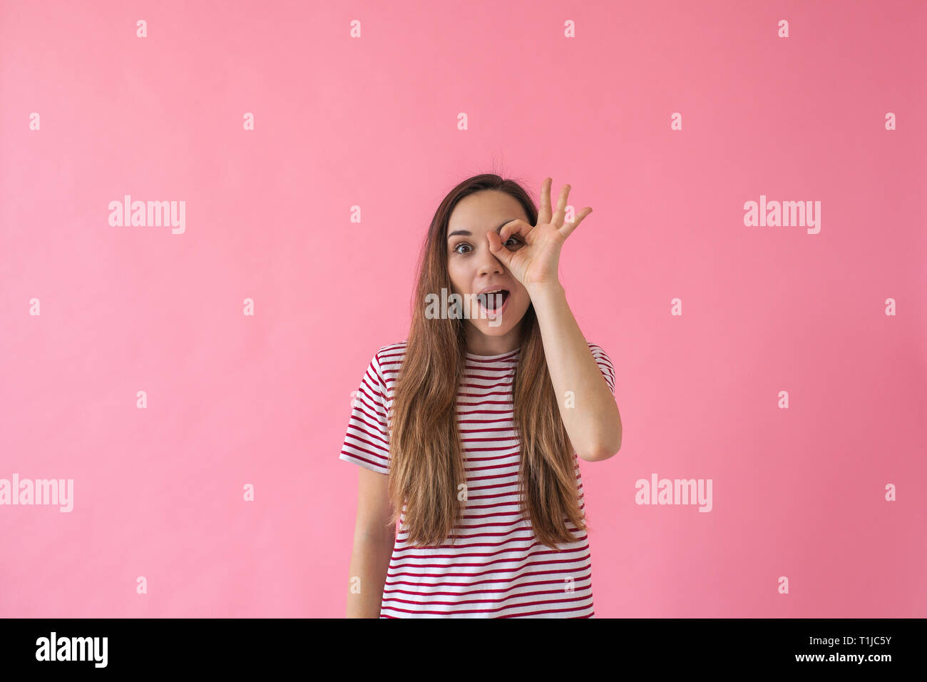 Positive beautiful young girl making a hand sign Stock Photo - Alamy