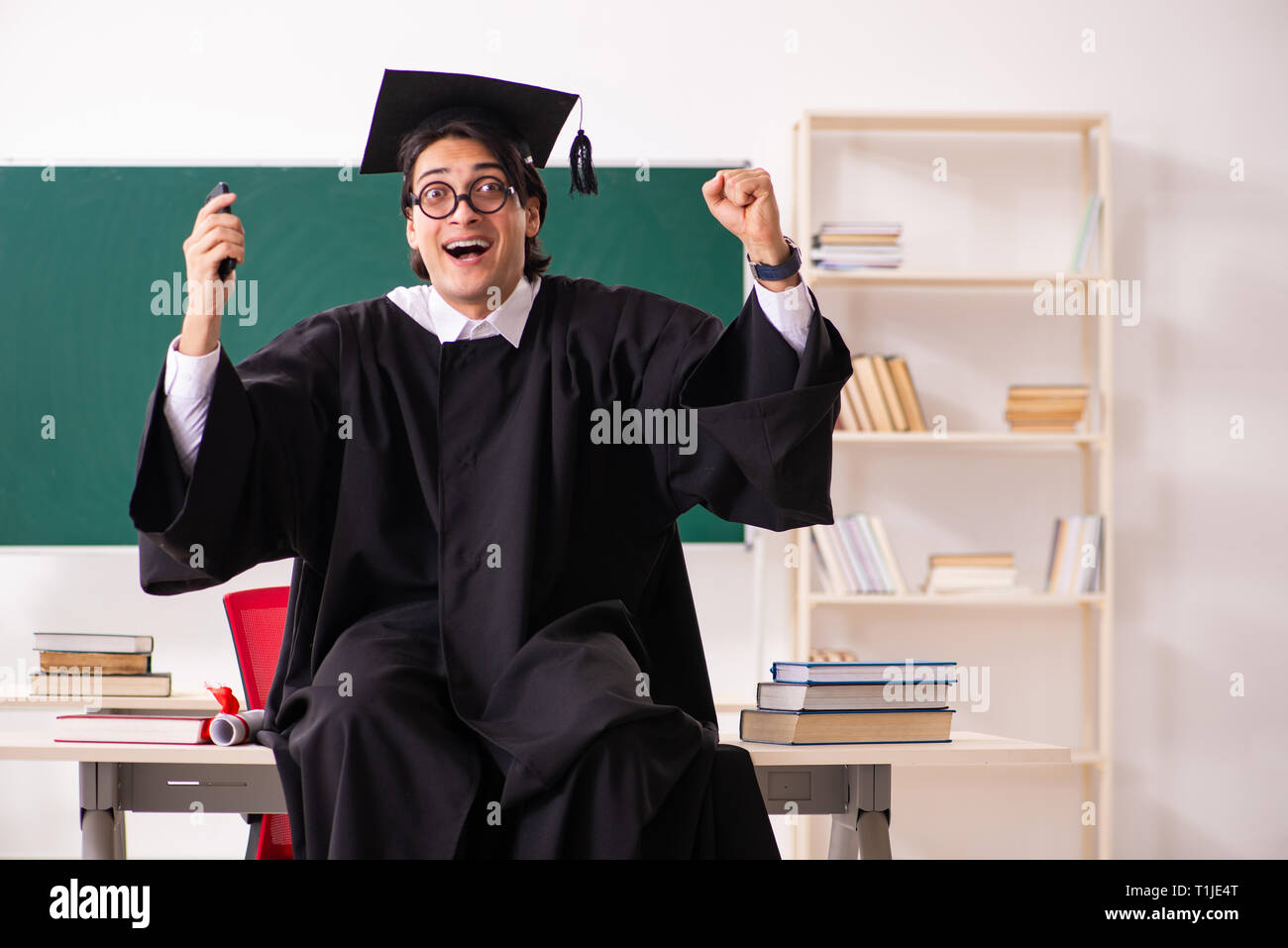 Graduate student in front of green board Stock Photo - Alamy