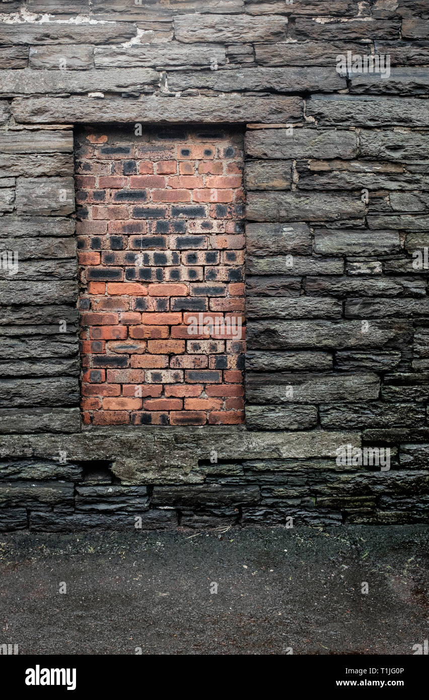 Exterior shot of bricked up window in an old brick work wall in and ...