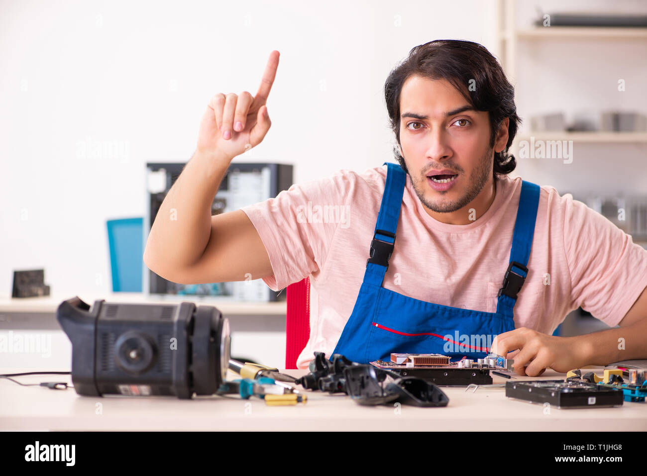 Young male contractor repairing computer Stock Photo - Alamy