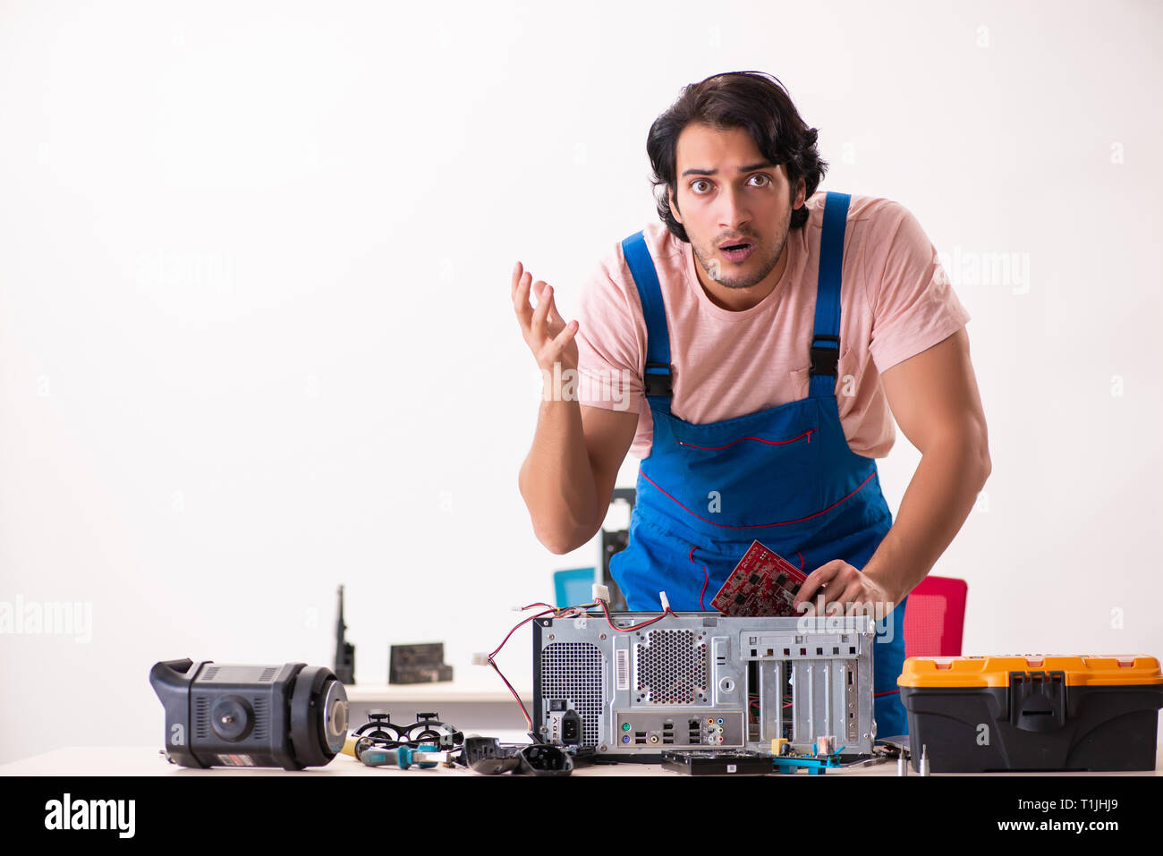 Young male contractor repairing computer Stock Photo - Alamy