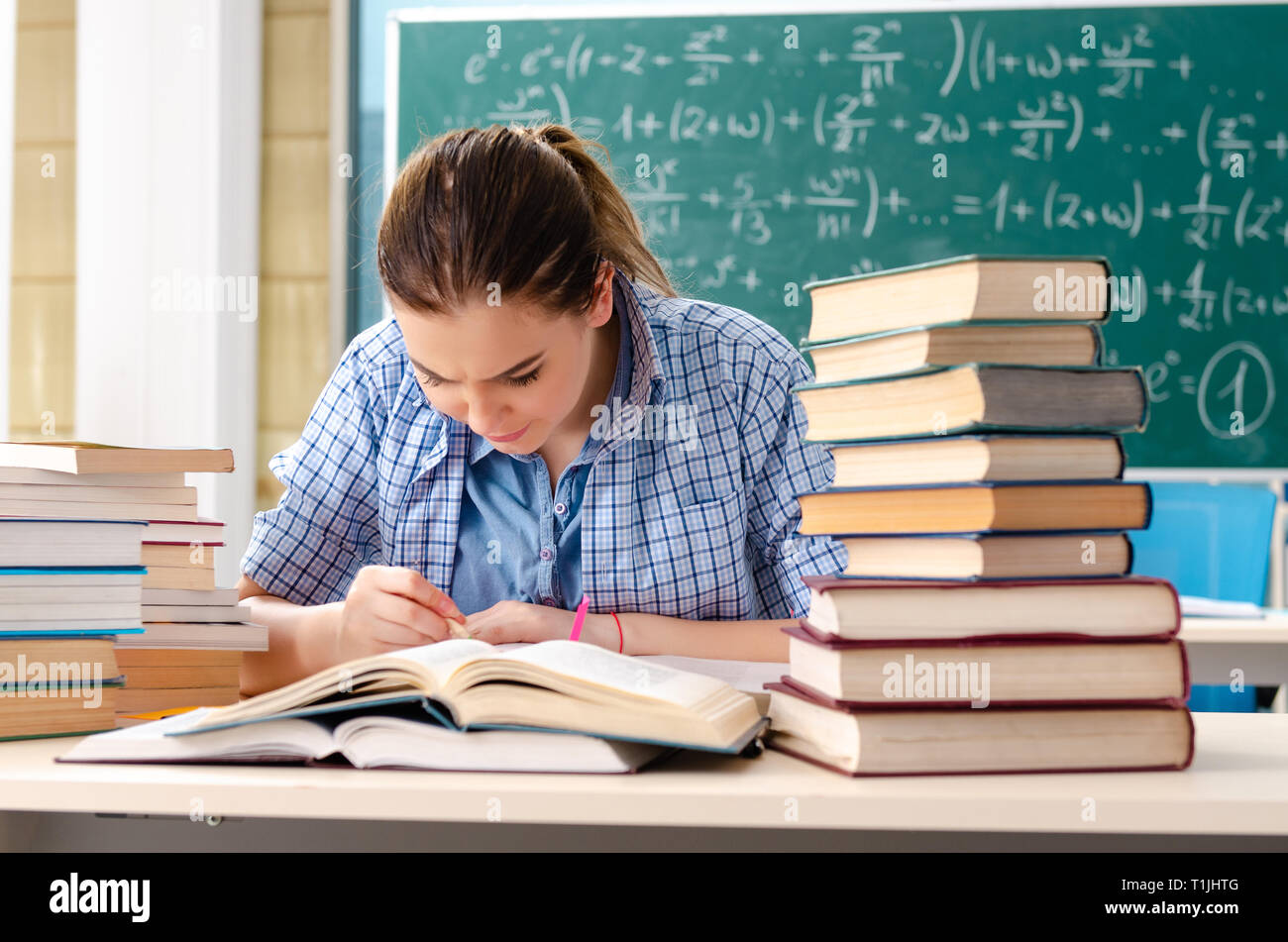 Female student with many books sitting in the classroom Stock Photo - Alamy