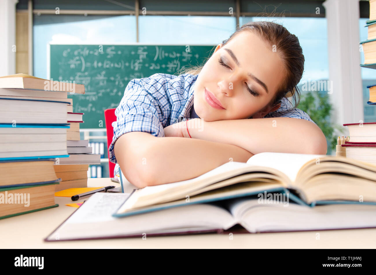 Female student with many books sitting in the classroom Stock Photo - Alamy