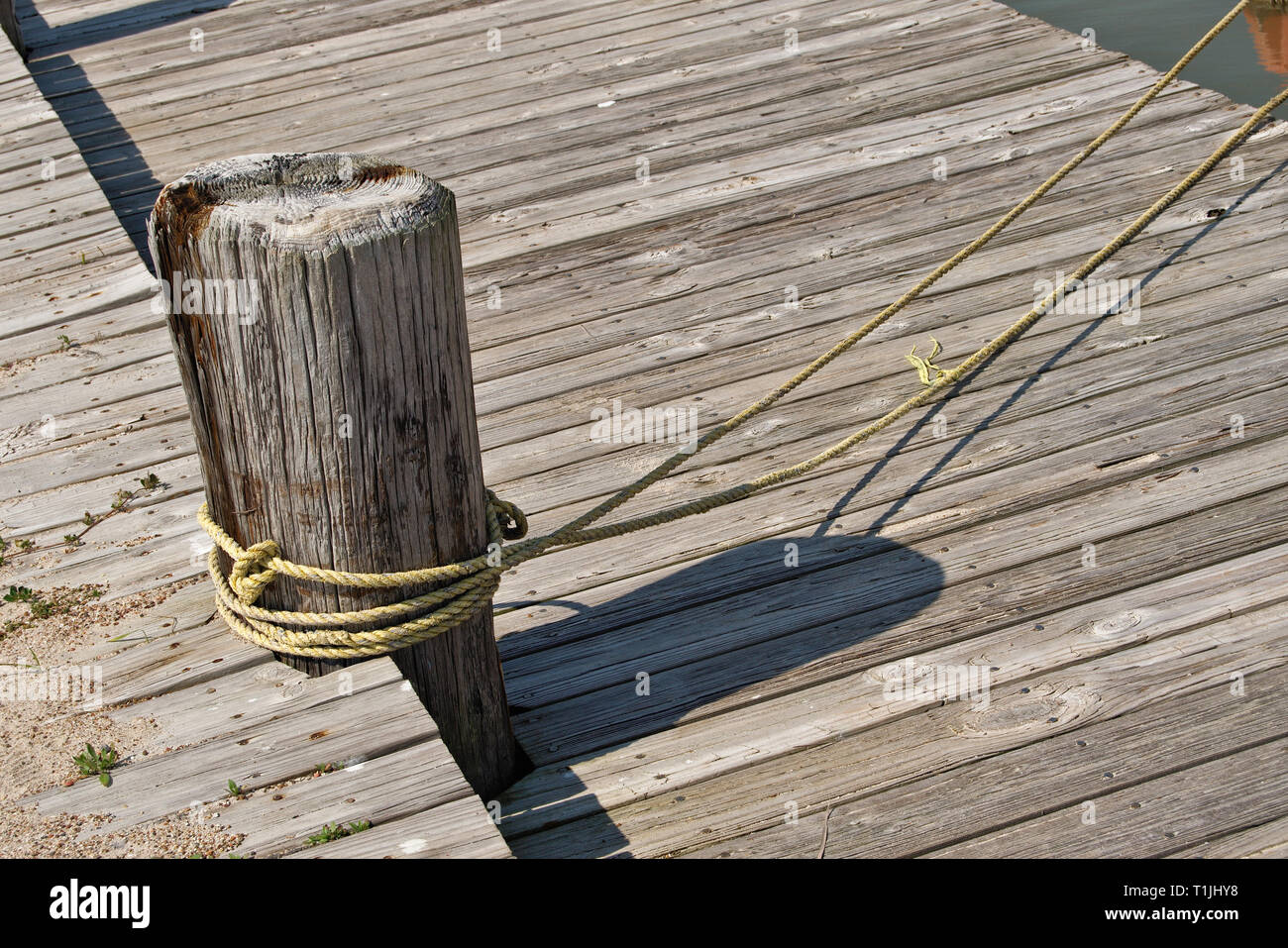 Wooden pile with rope tied around it Stock Photo - Alamy