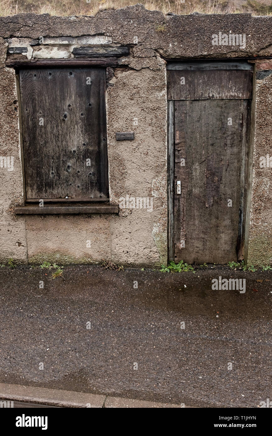 Exterior shots of crumbling grey rough cast wall in and around the ...