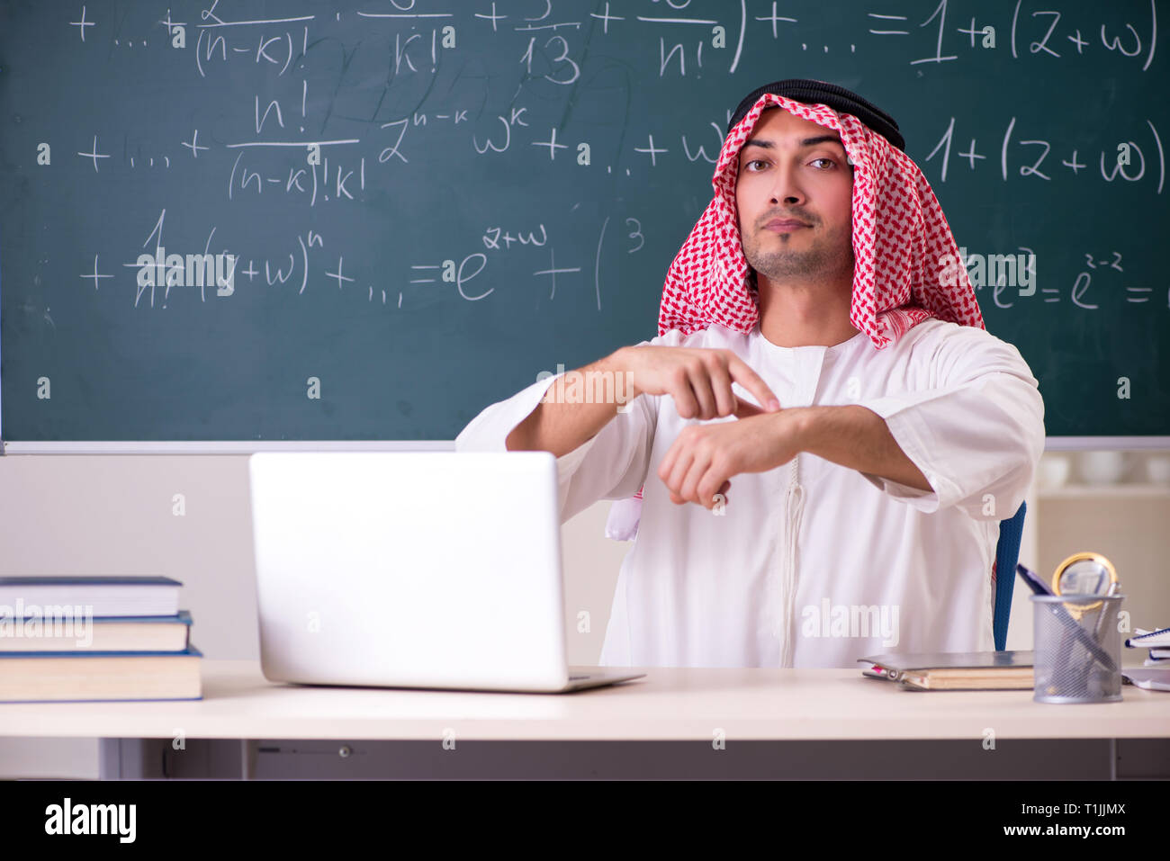 Arab teacher in front of chalkboard Stock Photo - Alamy