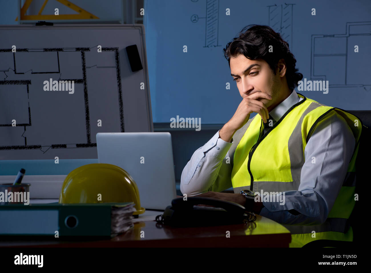 Young construction architect working on project at night Stock Photo ...