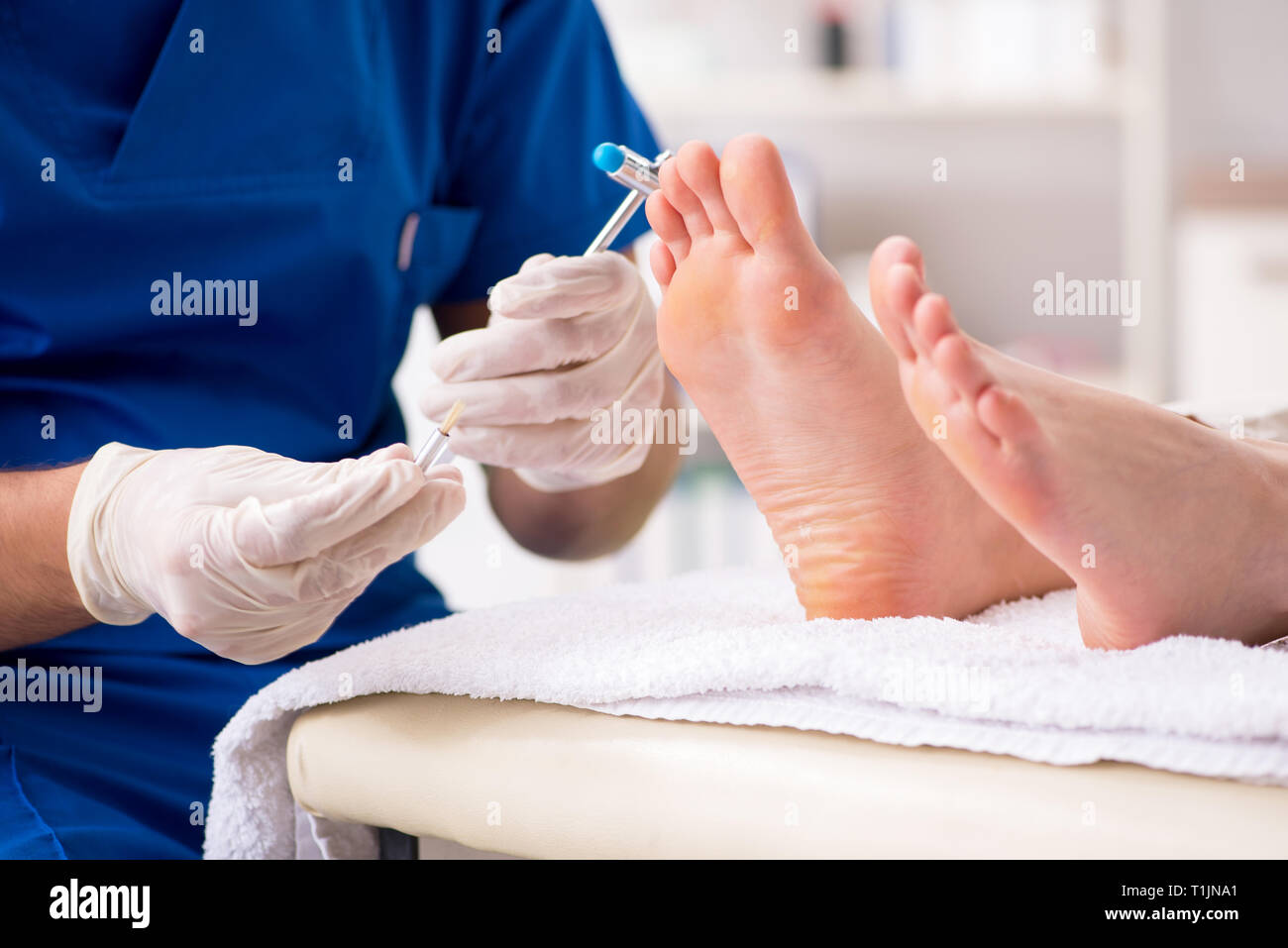Podiatrist treating feet during procedure Stock Photo - Alamy