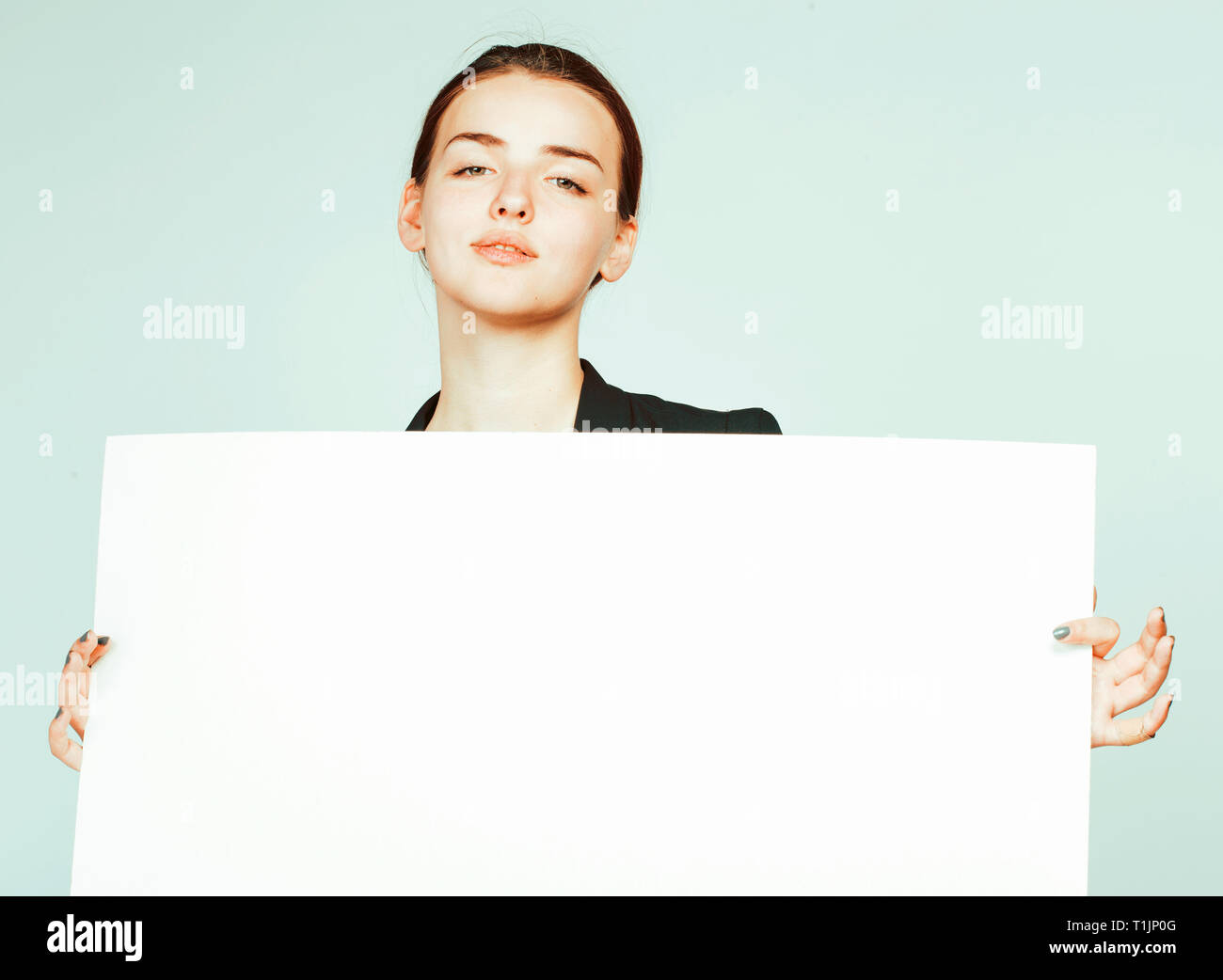 young pretty brunette girl with placard on white background wearing ...