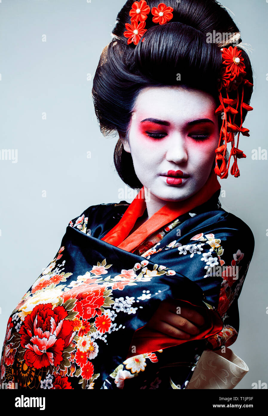 young pretty geisha in black kimono among sakura, asian ethno close up ...