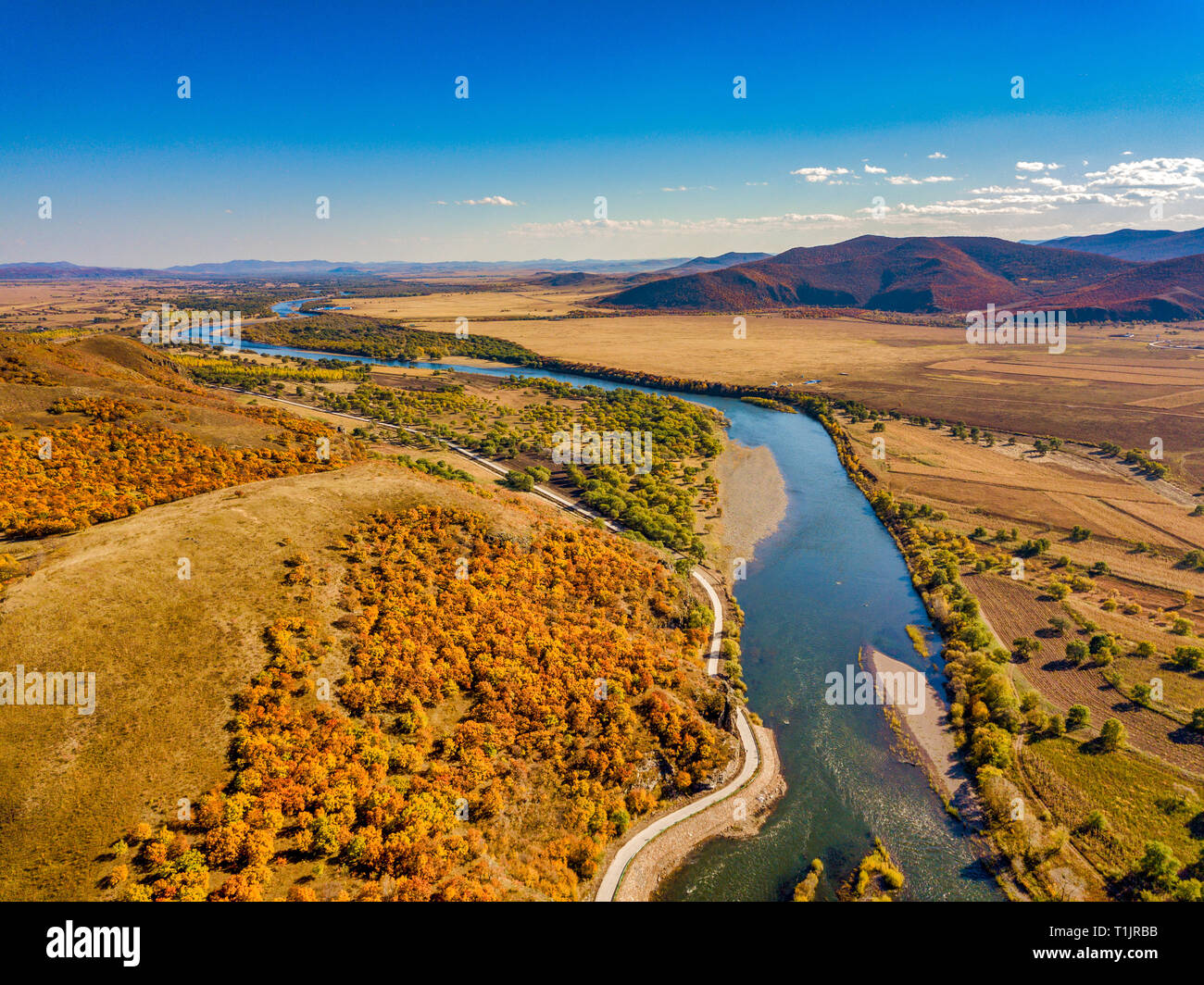 Aerial photograph of meandering river against mountains and grasslands ...