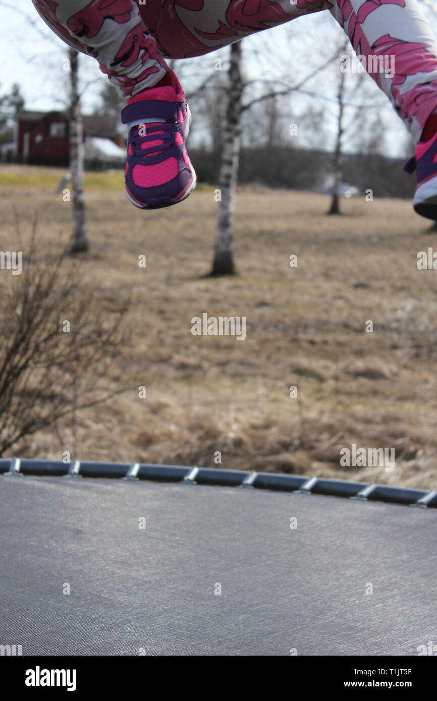 A child jumping high up in the air while jumping on a trampoline Stock ...