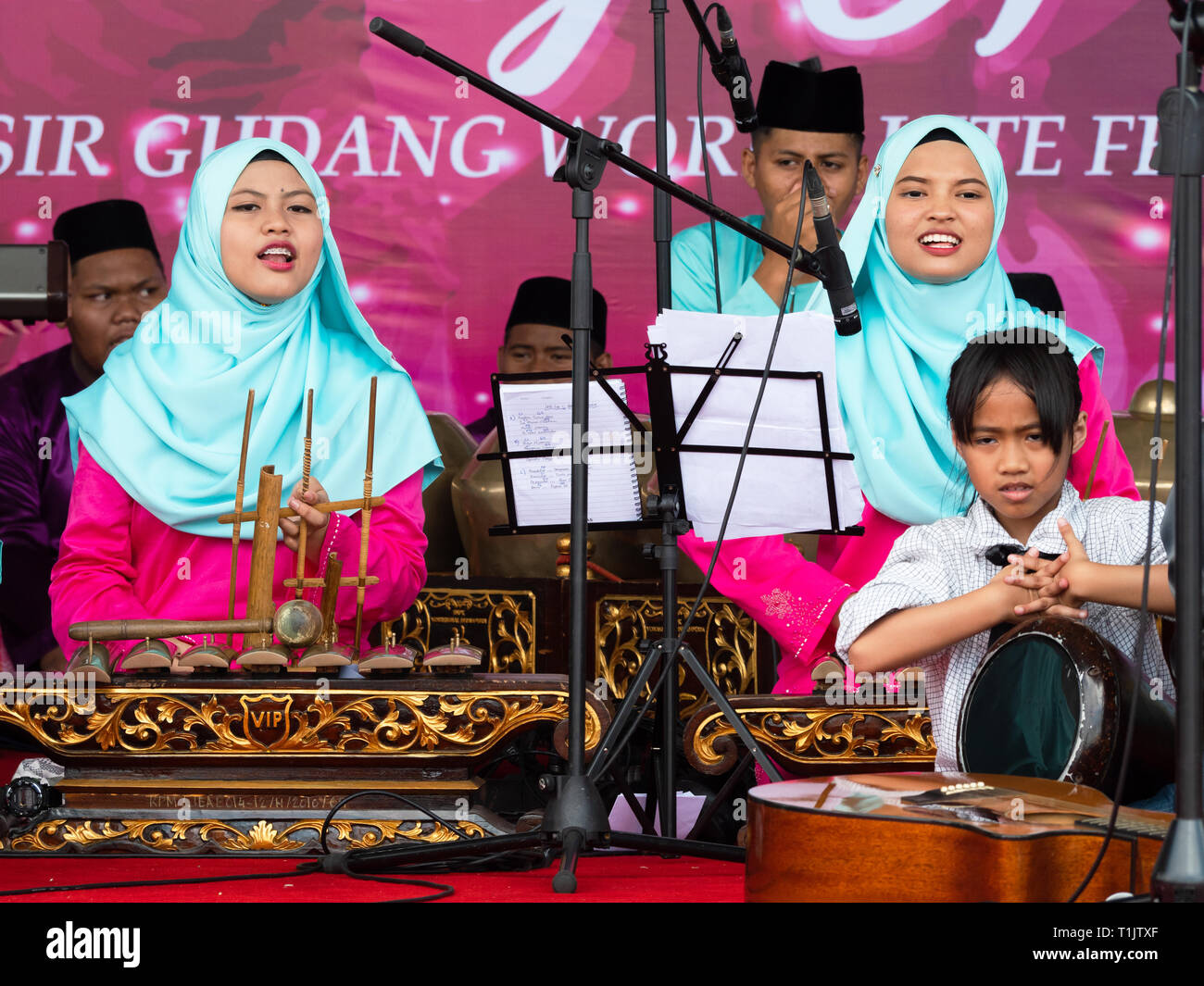 Malaysian orchestra playing traditional instruments and wearing ...