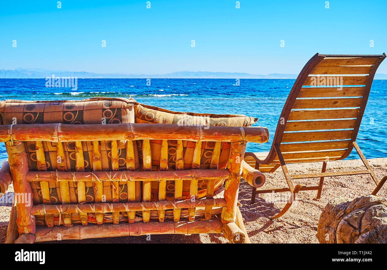 The nice beach of Dahab with cozy rocking-chairs and bamboo benches of ...
