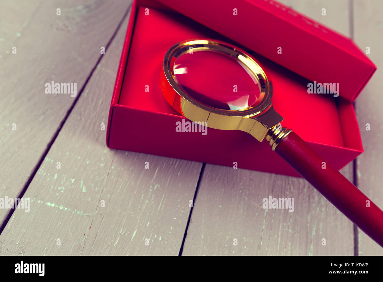 Gift box with magnifying glass Stock Photo - Alamy