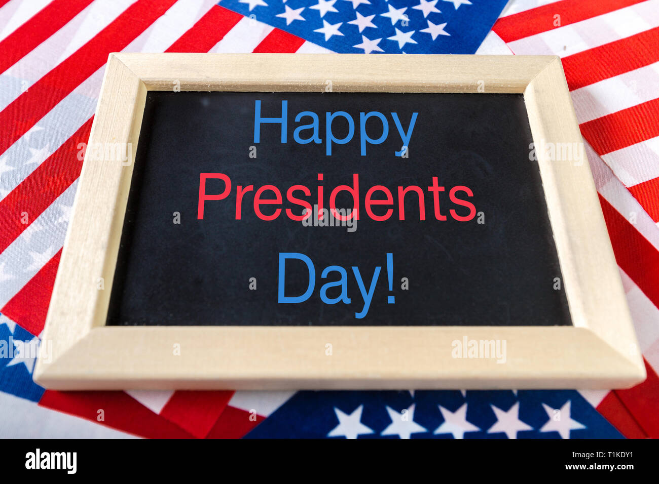 the text happy presidents day written in a chalkboard and a flag of the ...