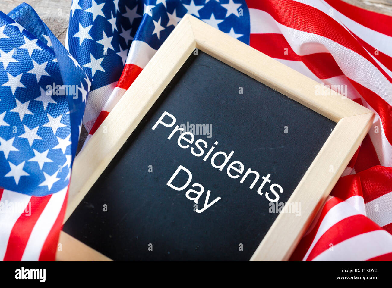 the text happy presidents day written in a chalkboard and a flag of the ...