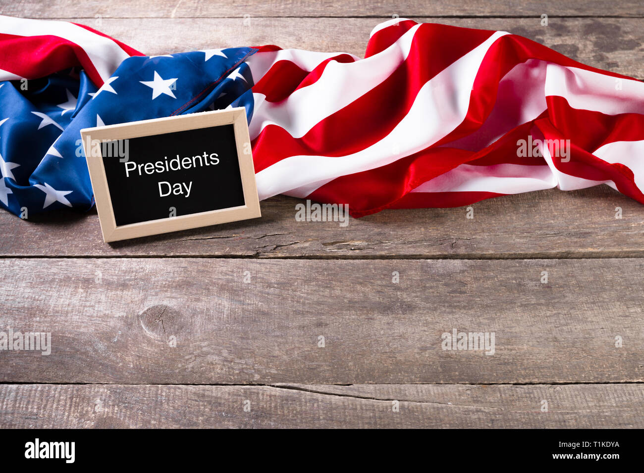the text happy presidents day written in a chalkboard and a flag of the ...