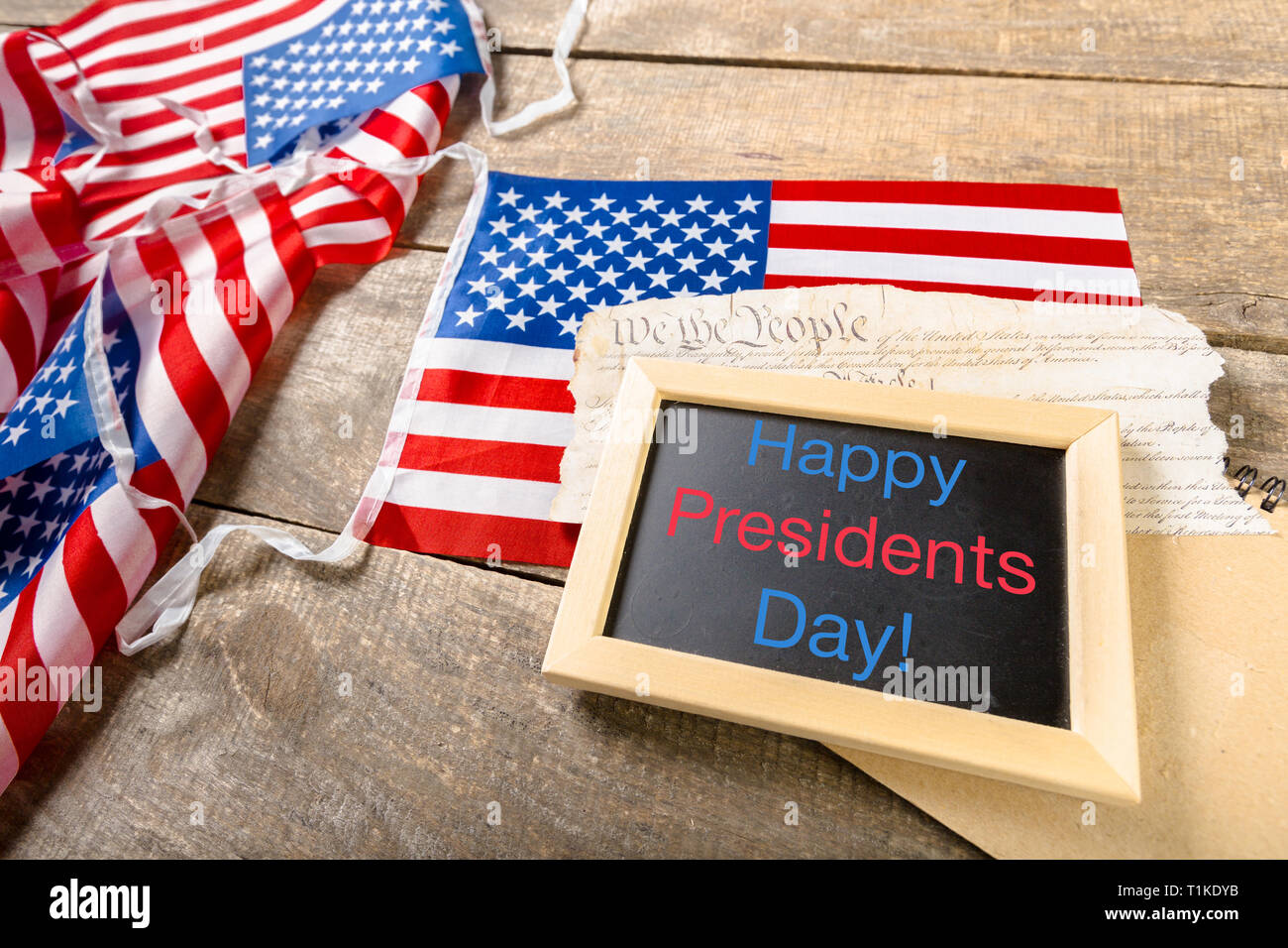 the text happy presidents day written in a chalkboard and a flag of the ...