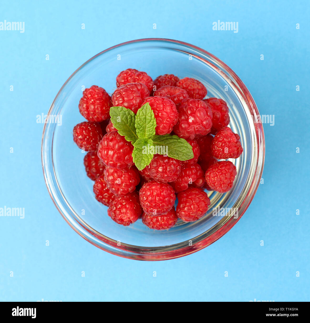 Fresh raspberries with leaves of mint on blue background Stock Photo ...