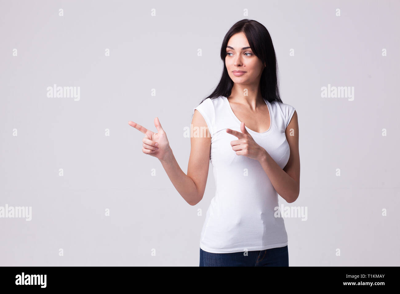Beautiful brunette woman portrait points with her arms to the side ...