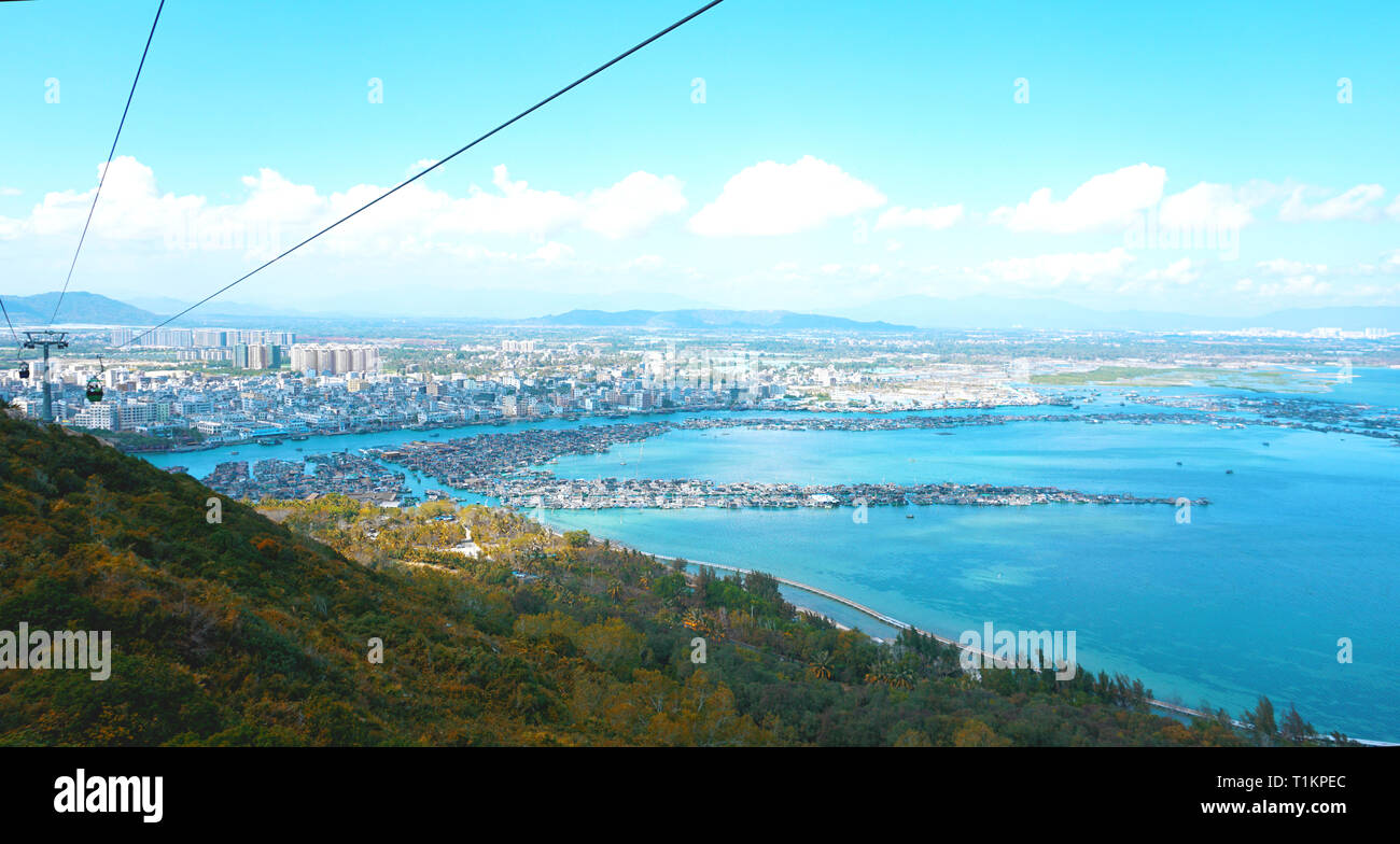 Cable car with tourists inside and against the background of the Hainan ...