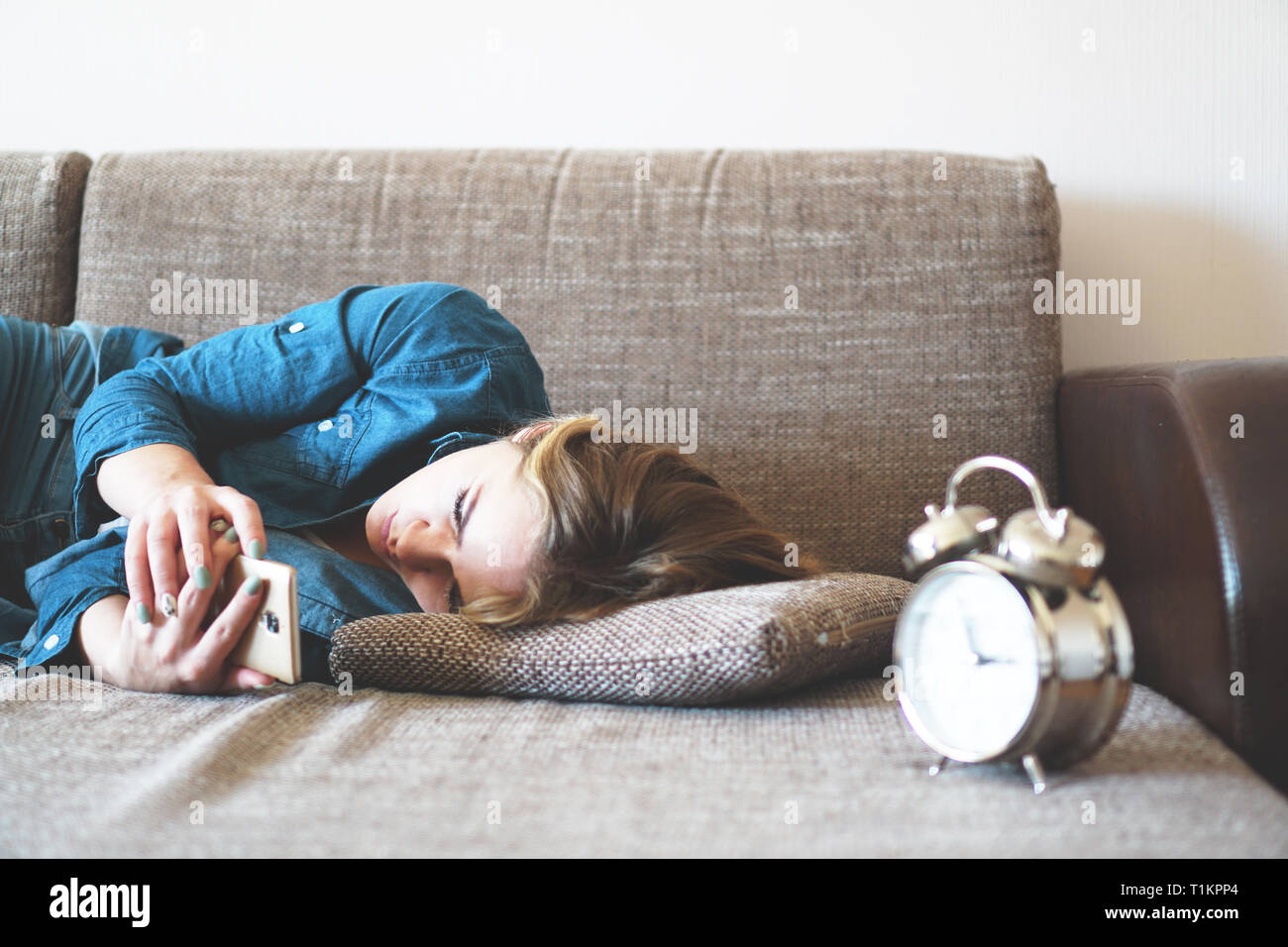 Young woman using phone in bed, looking at screen, insomnia, check time ...