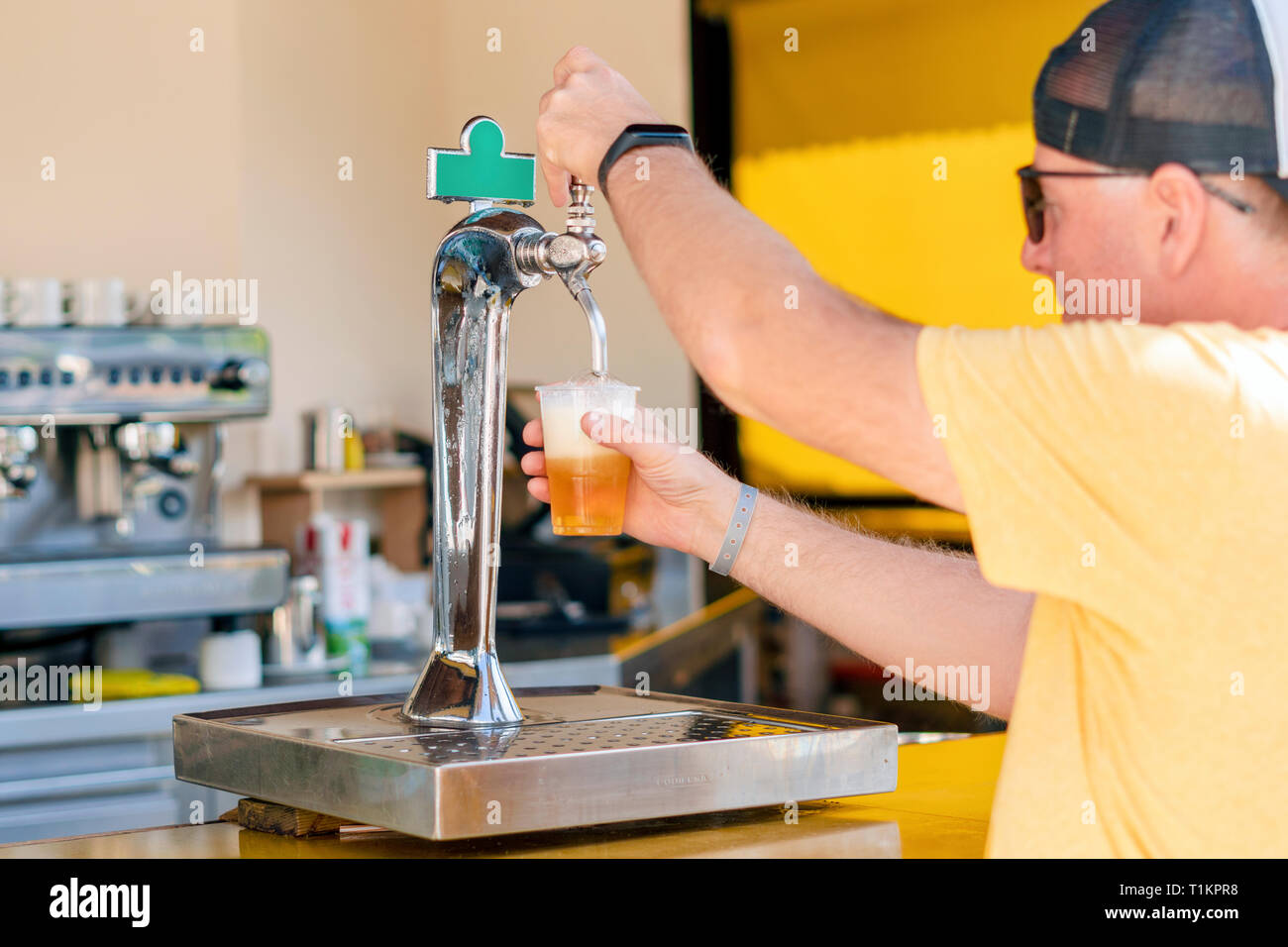 Man pouring fresh beer in self service bar - with all inclusive badge ...