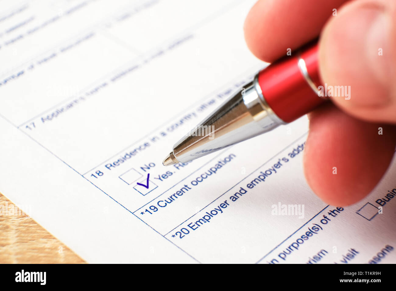 Schengen visa, questionnaire. Hand with pen completing a questionary ...