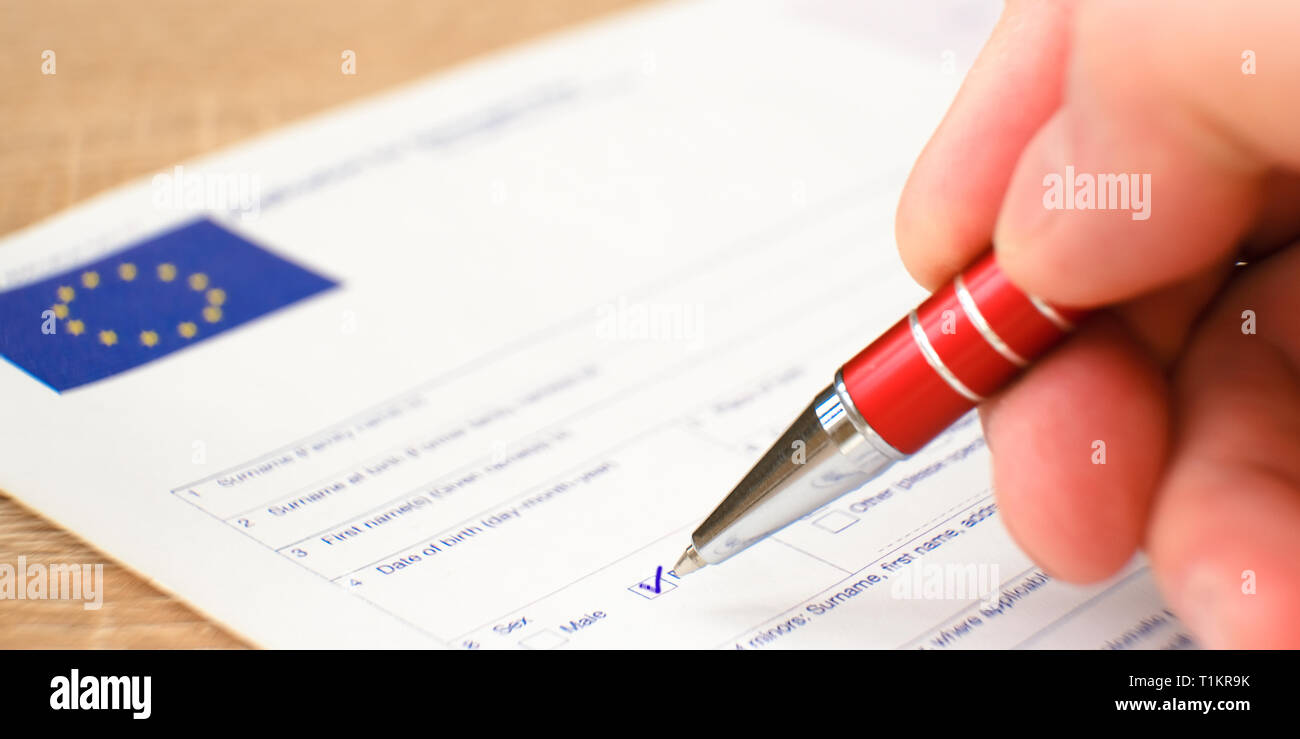 Schengen visa, questionnaire. Hand with pen completing a questionary ...