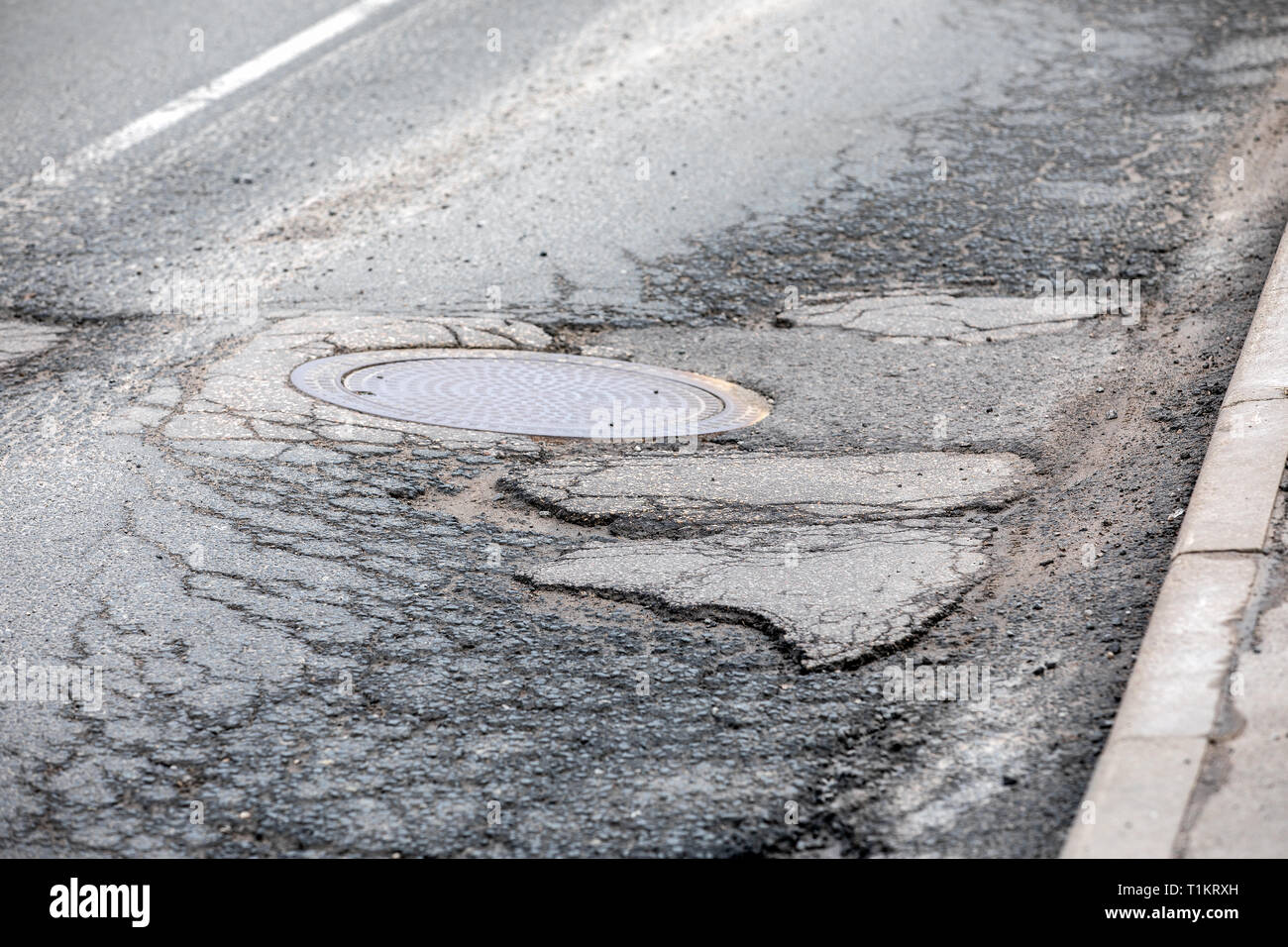 Damaged asphalt road with potholes Stock Photo - Alamy