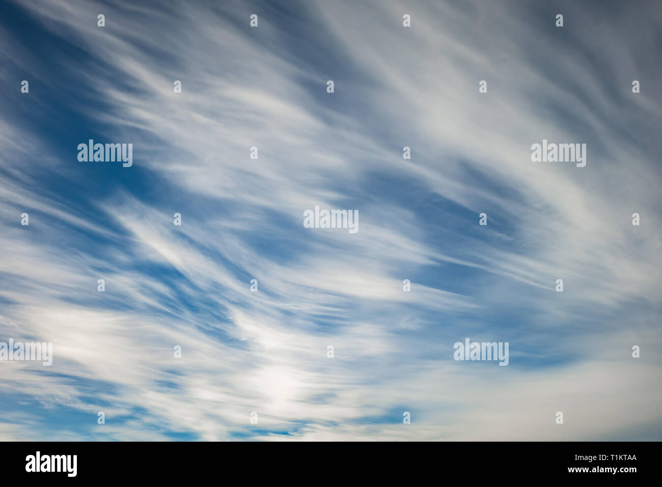 Blue sky background with tiny stratus cirrus striped clouds. Clearing ...