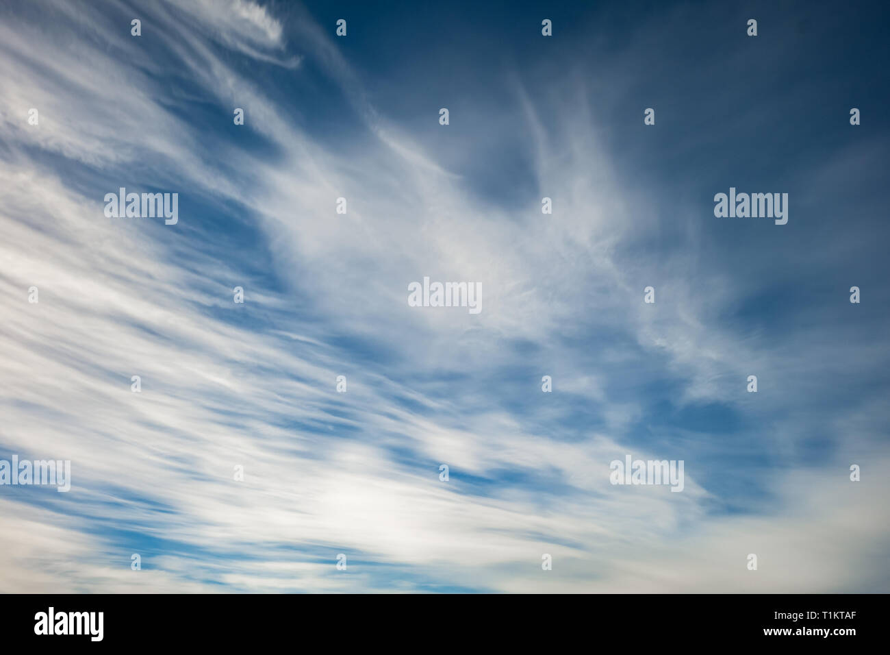 Blue sky background with tiny stratus cirrus striped clouds. Clearing ...