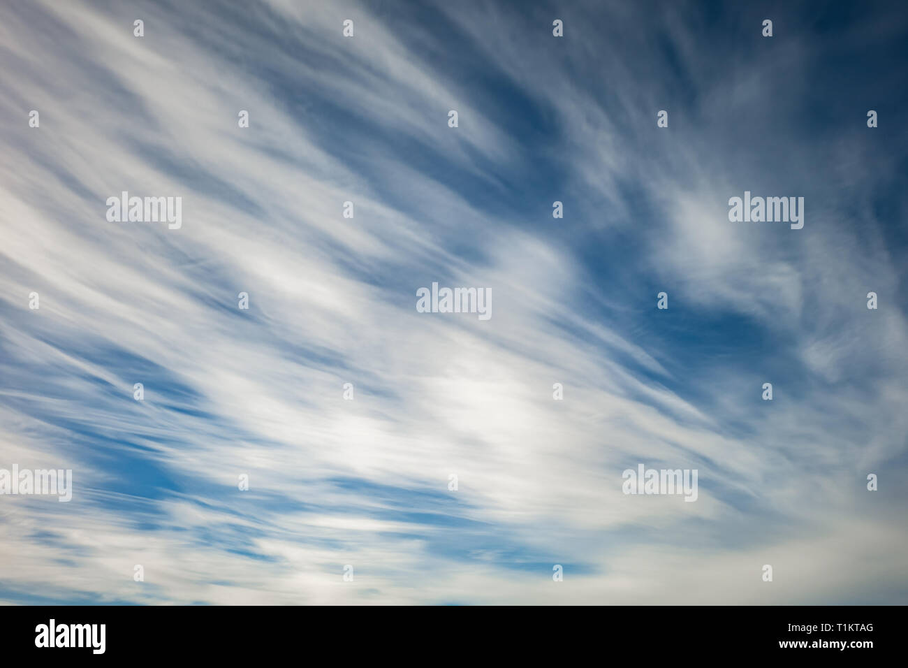 Blue sky background with tiny stratus cirrus striped clouds. Clearing ...