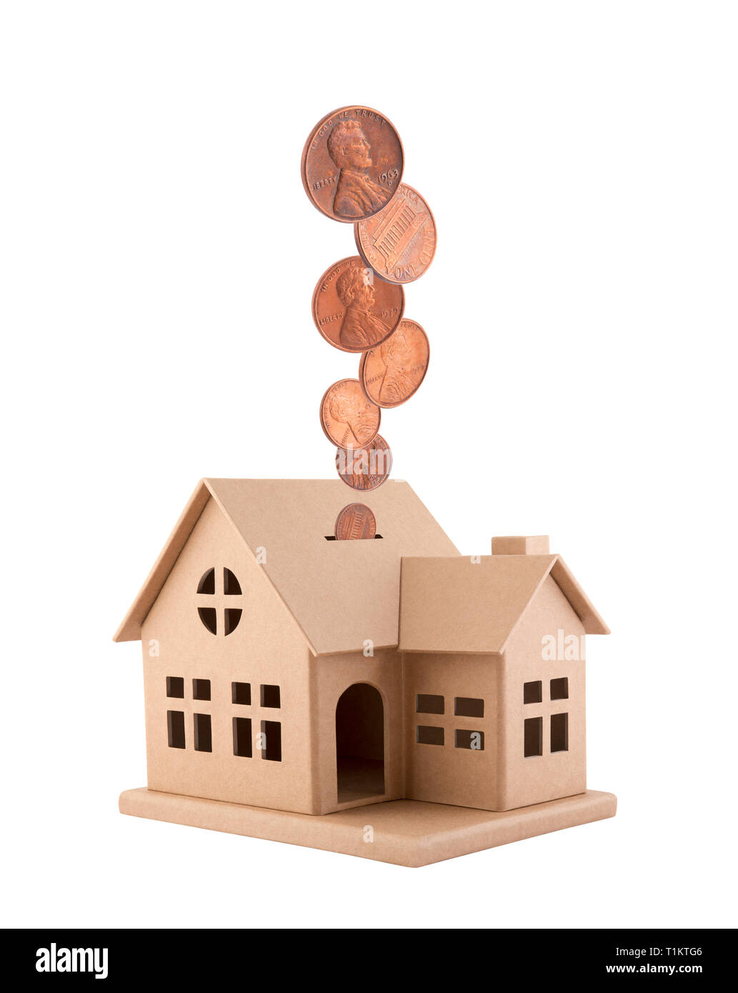 Cardboard house with coins falling into the slot isolated on white ...