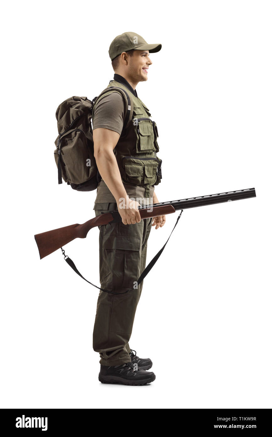 Full length profile shot of a young man hunter standing with a shotgun ...
