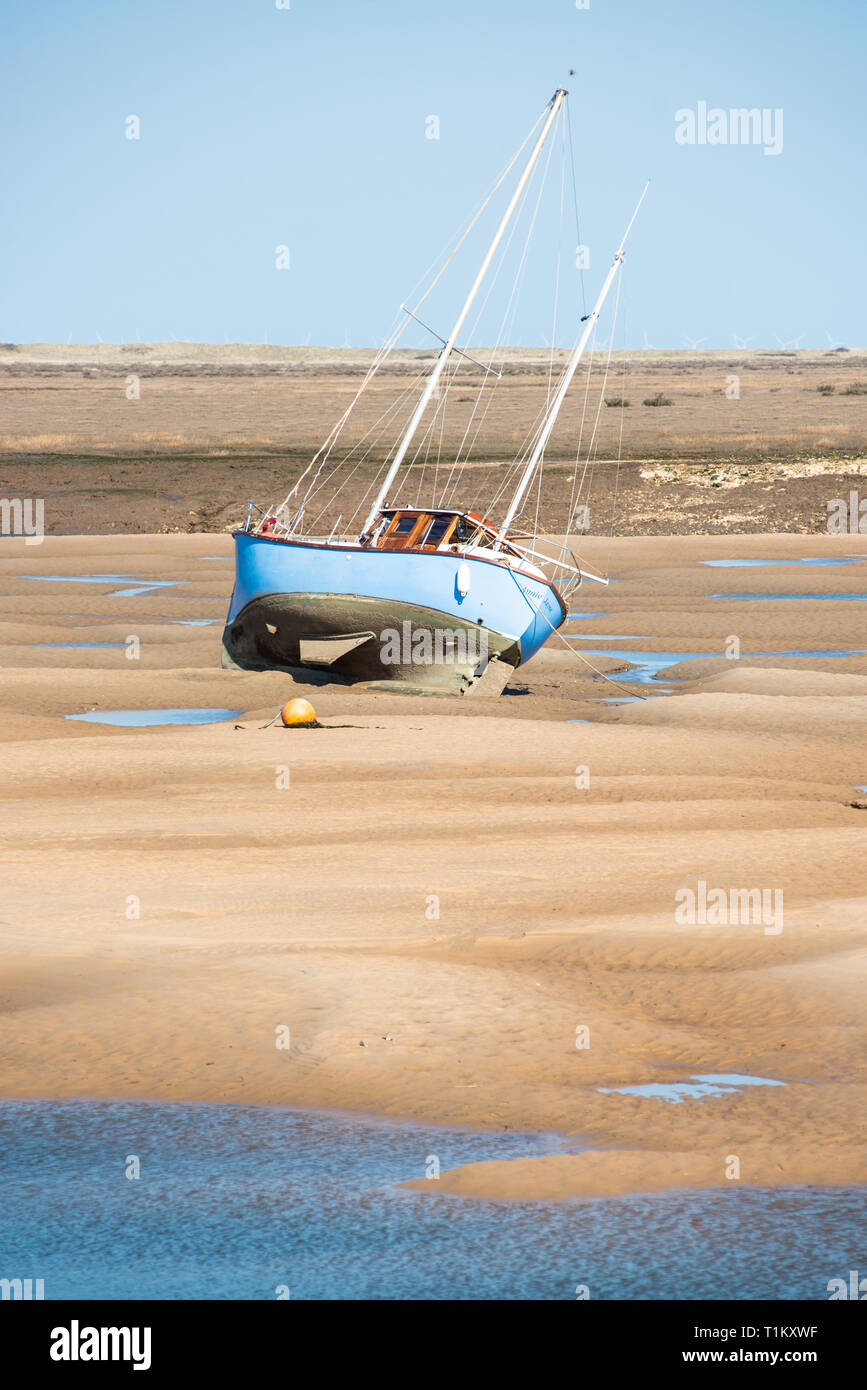 Colourful boats marooned on sandbanks at low tide on East Fleet river ...