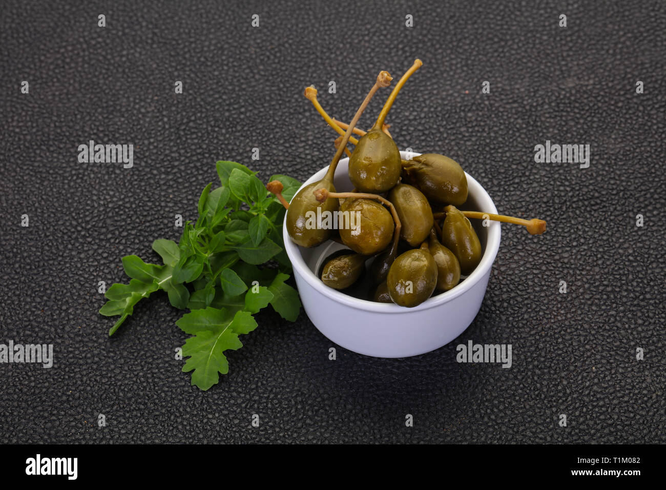 Pickled Capersberries in the bowl with basil Stock Photo - Alamy