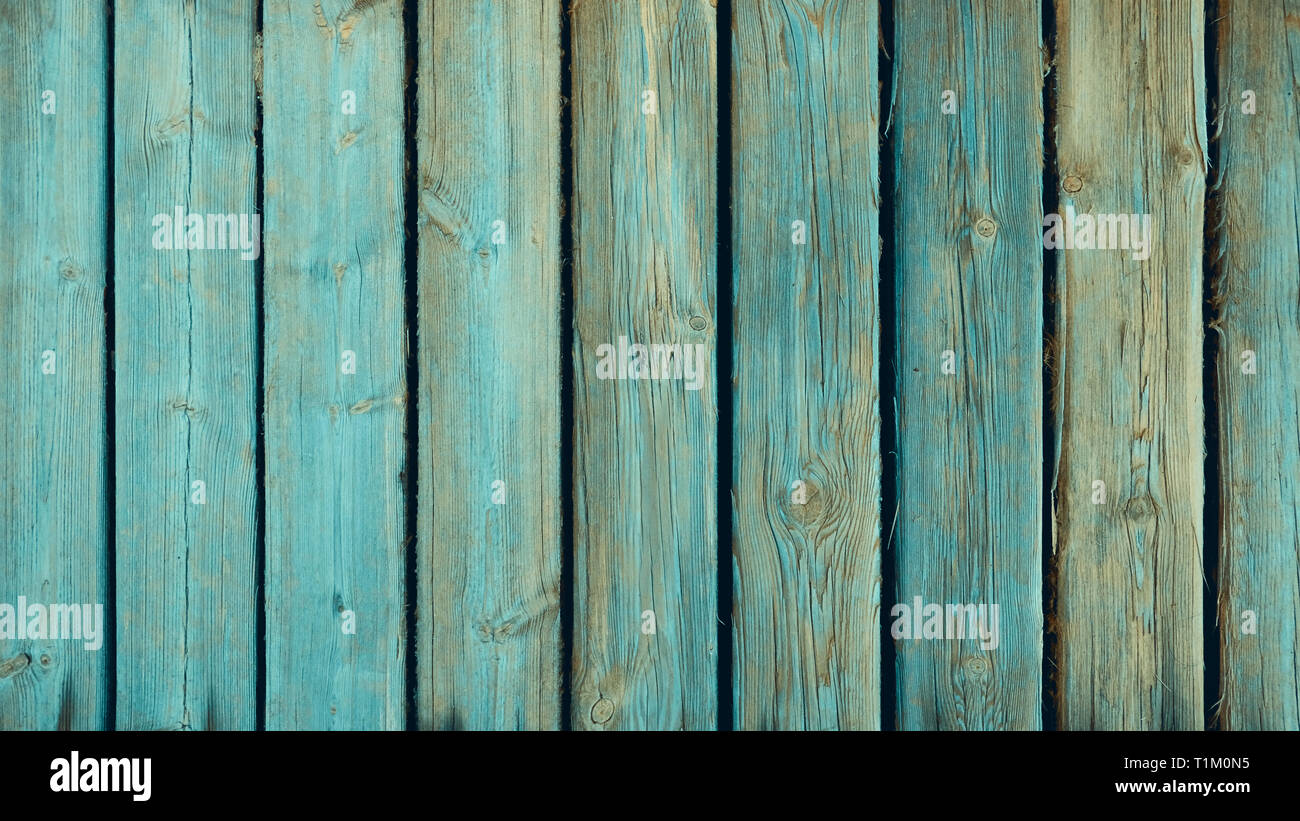 Weathered and distressed wooden panels with traces of teal green paint ...