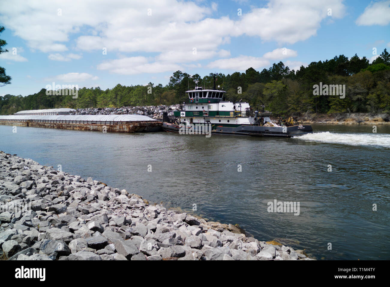 Tugboat pushes a barge westward on the Intracoastal Waterway through ...