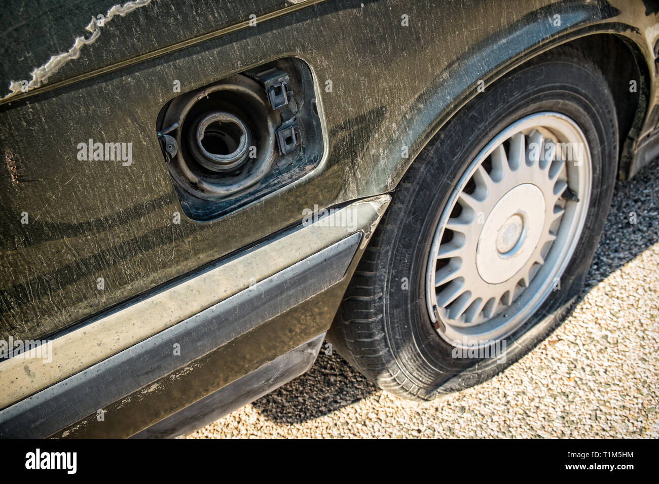 Wasted care with punctured tyres and and open fuel tank Stock Photo - Alamy