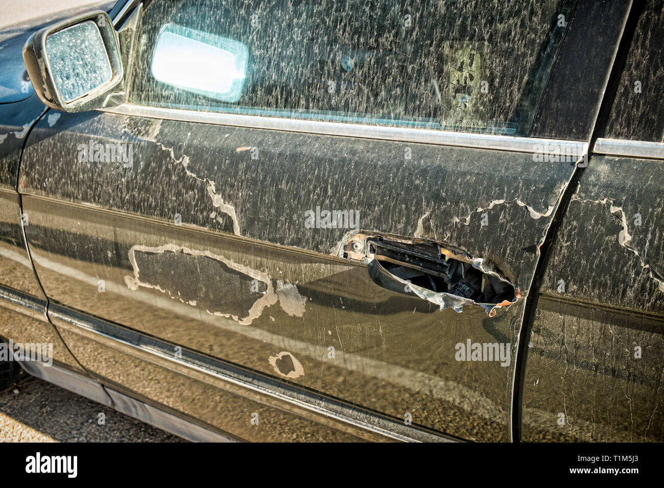 Broken into door of a car rotting on the street Stock Photo - Alamy